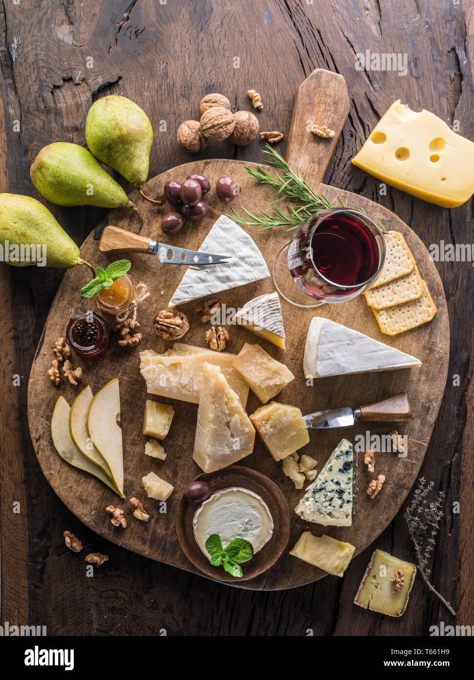 Cheese platter with organic cheeses, fruits, nuts and wine on wooden ...