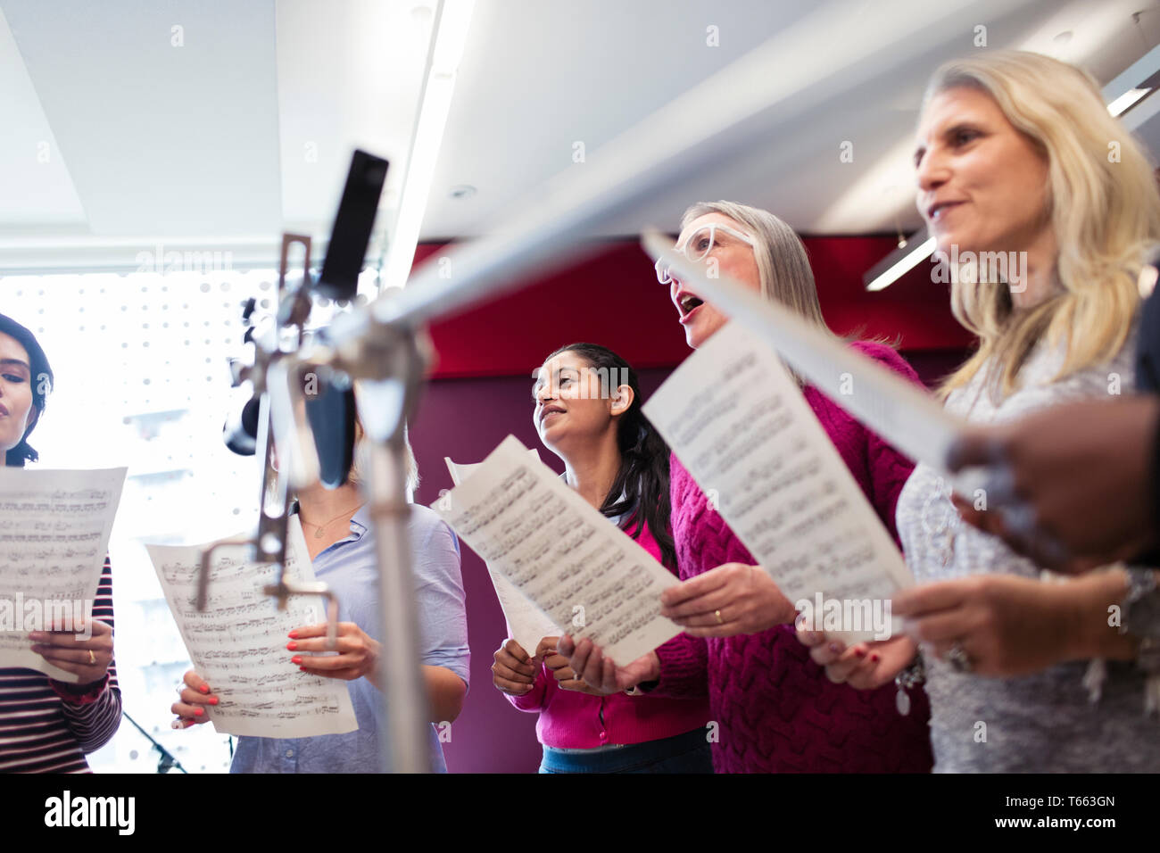 Womens choir with sheet music singing in music recording studio Stock ...