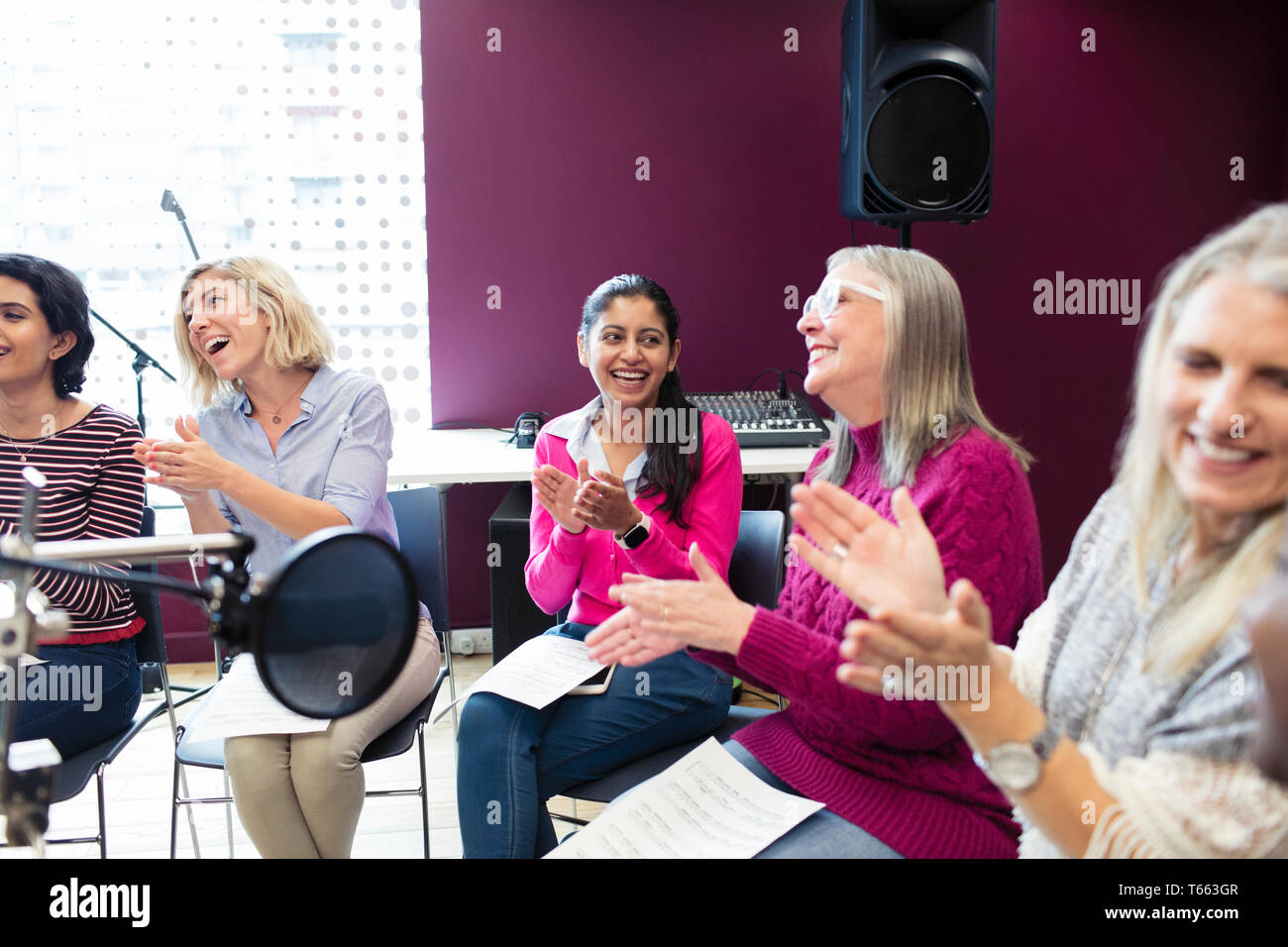 Happy womens choir with sheet music singing and clapping in music ...