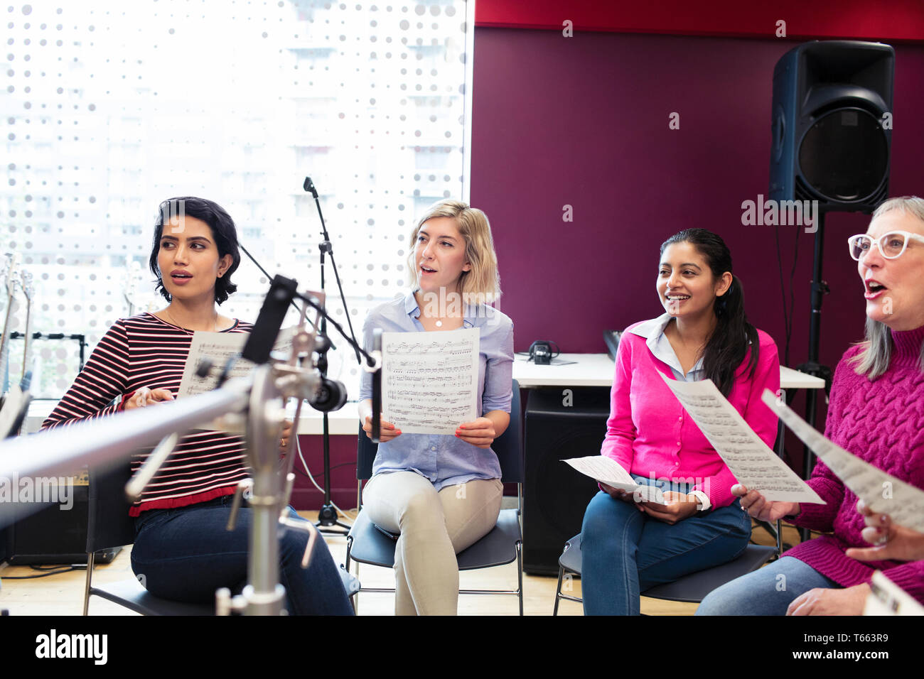 Womens choir with sheet music singing in music recording studio Stock ...