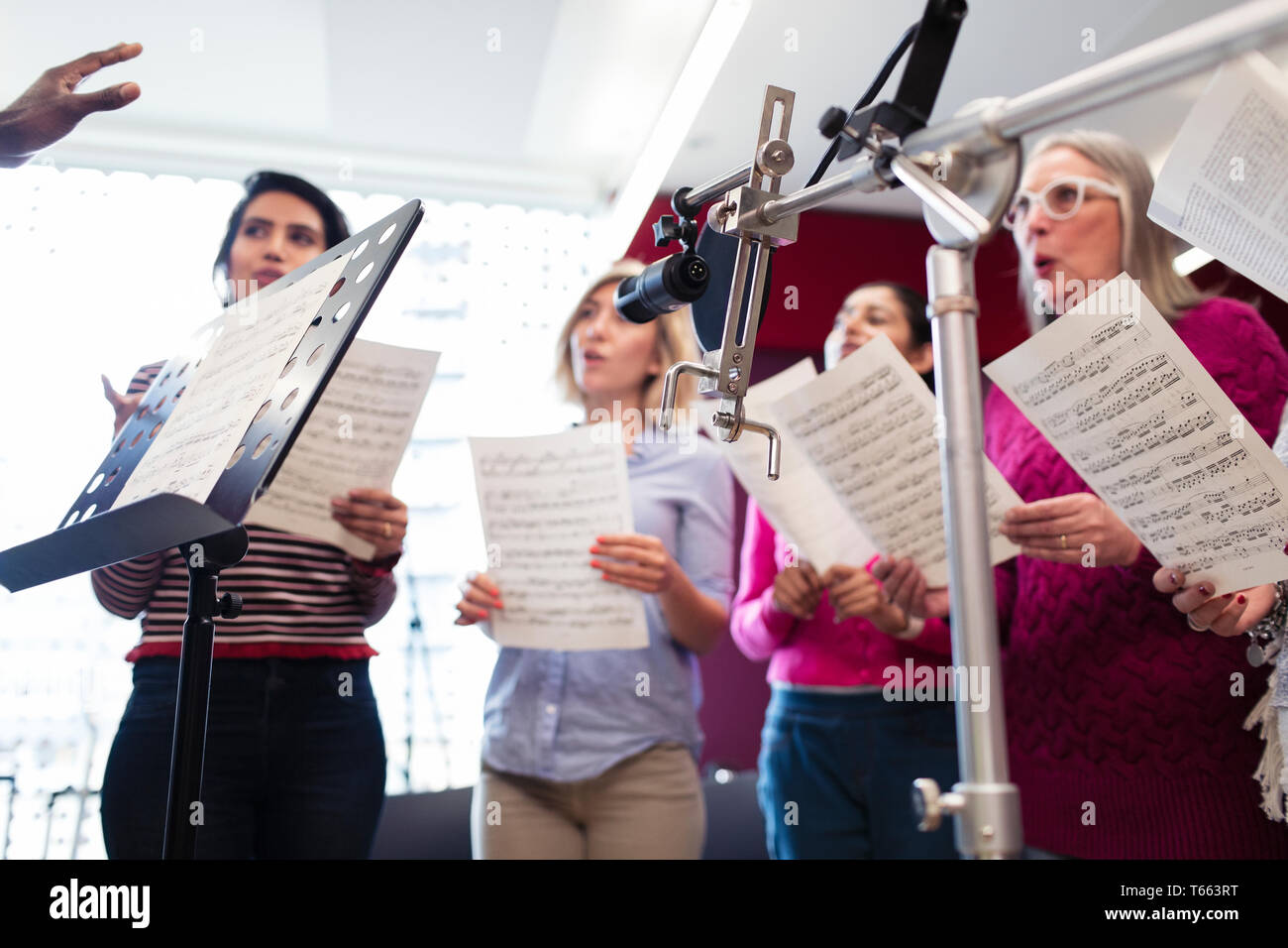 Womens choir with sheet music singing in music recording studio Stock ...