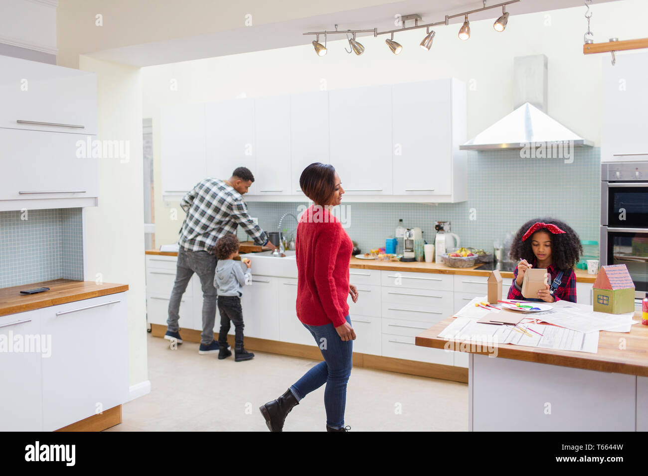Family doing dishes and making crafts in kitchen Stock Photo - Alamy