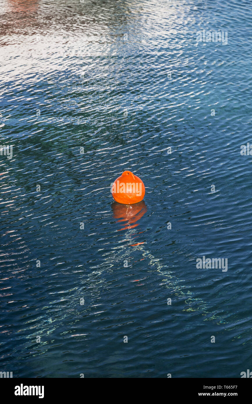 orange buoy in blue ocean water Stock Photo - Alamy