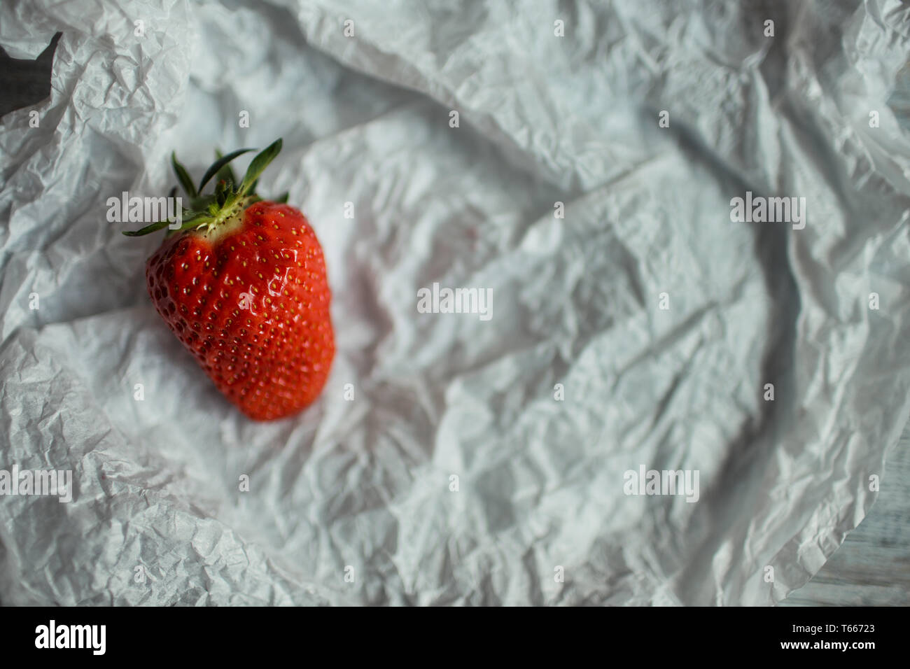 Single fresh red strawberry on simple background Stock Photo - Alamy
