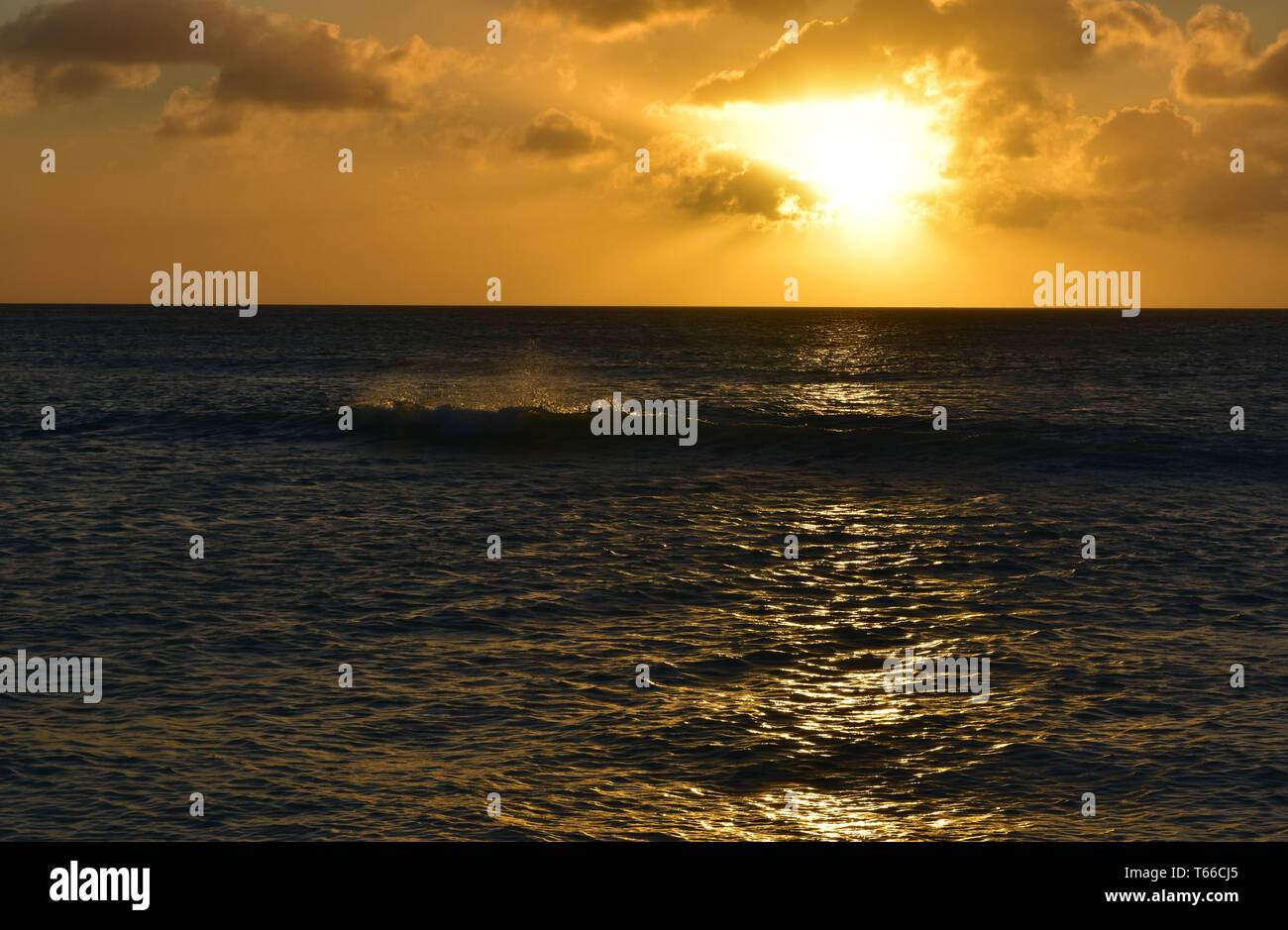 Stunning sunset with crashing waves in Aruba Stock Photo - Alamy