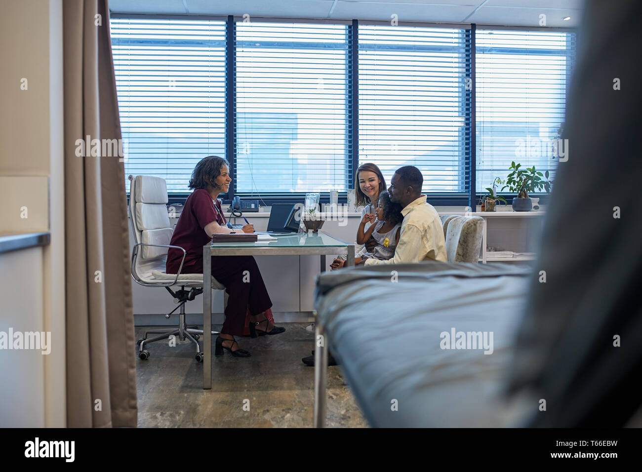 Doctor talking with family in clinic doctors office Stock Photo - Alamy