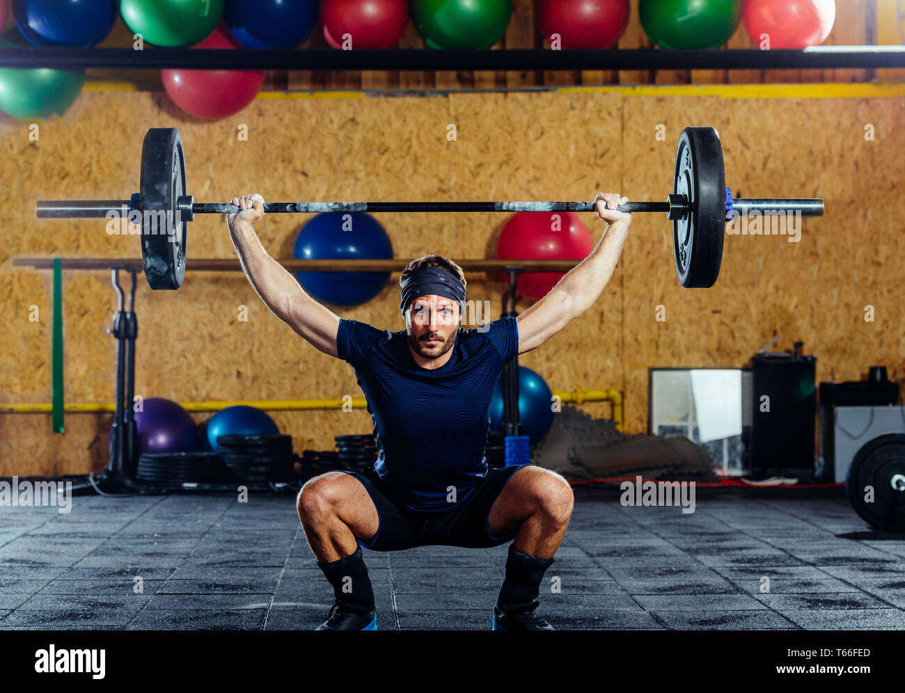 Good looking man is raising barbell in the gym Stock Photo - Alamy