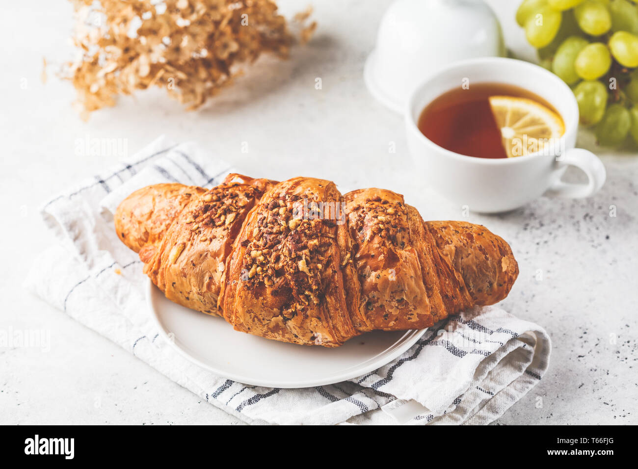 Croissant and tea for breakfast on a white background Stock Photo - Alamy