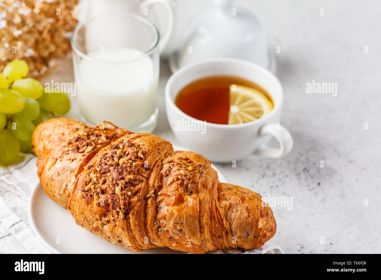 Croissant and tea for breakfast on a white background Stock Photo - Alamy