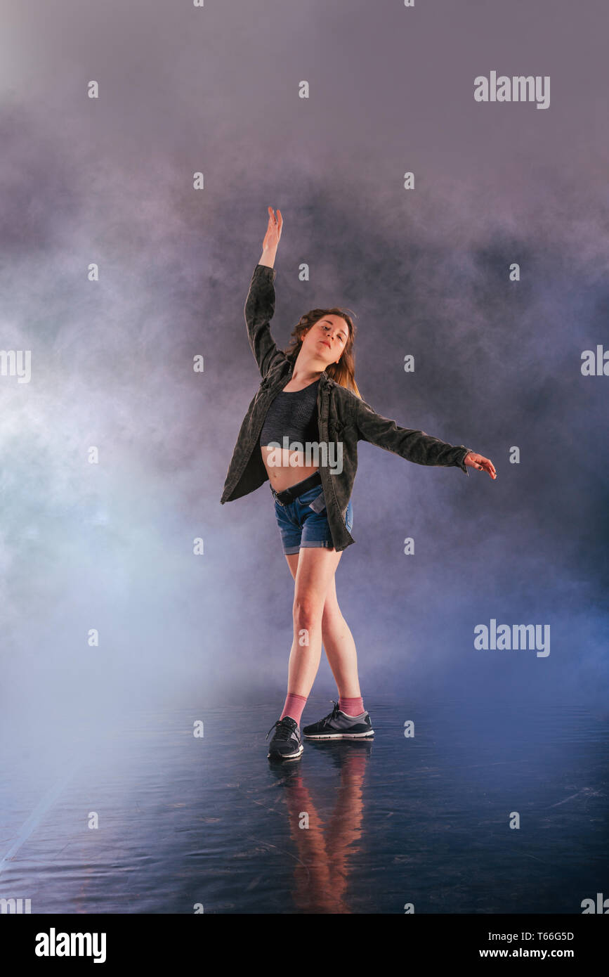 Female dancer shows off her elegance by moving her back leg high over ...