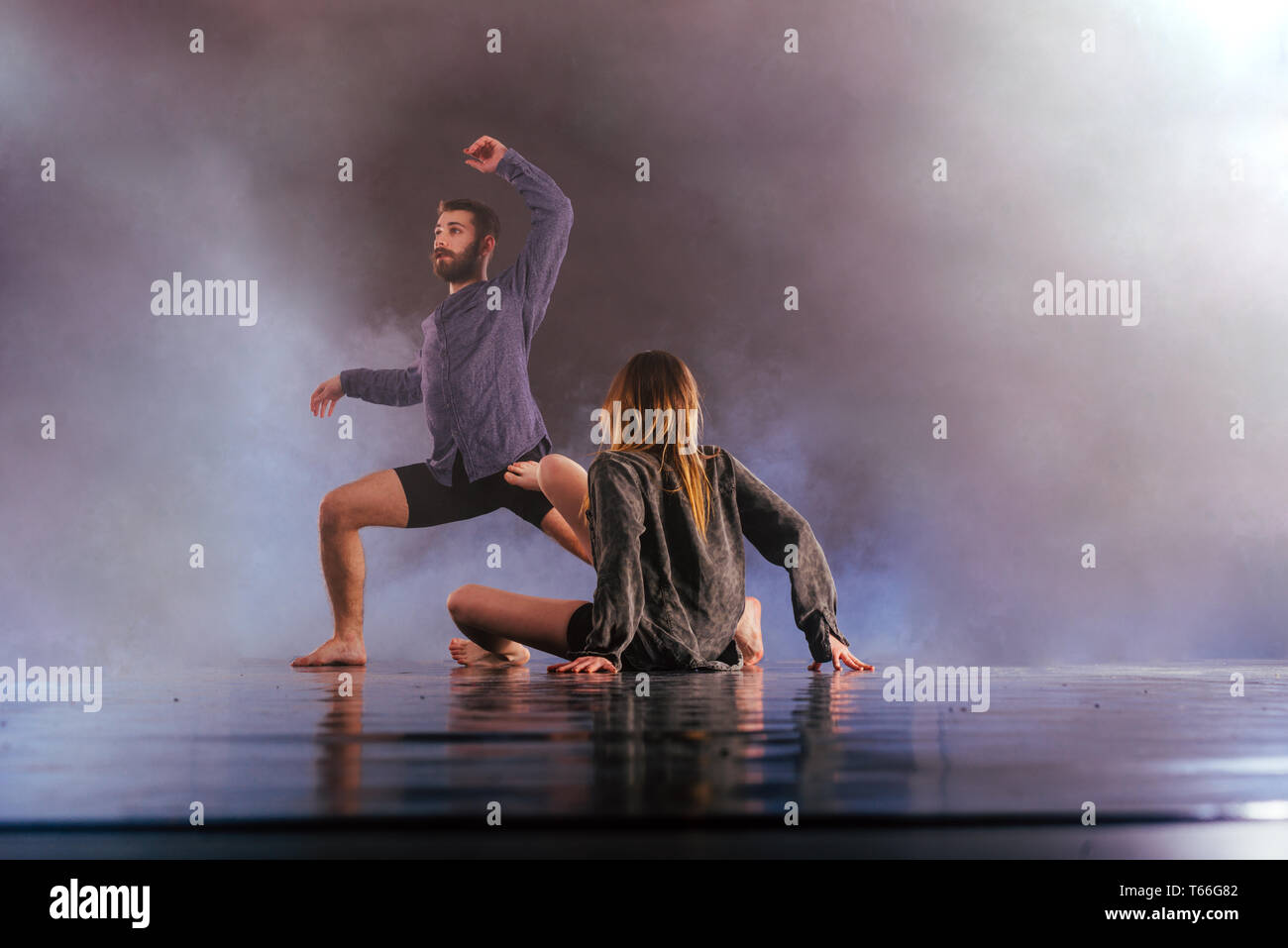 Shoeless dance couple performing multiple unique dance moves in front ...