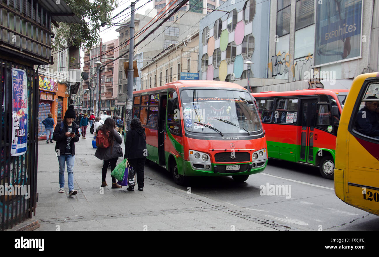 Brightly coloured mini-buses stop in downtown Valparaiso, Chile, to ...
