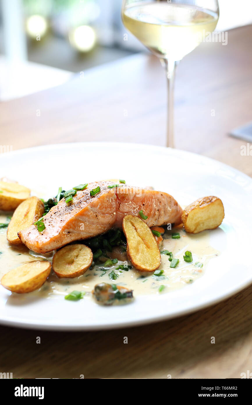 Elegant, exquisite dinner dish served on white plates with a glass of ...