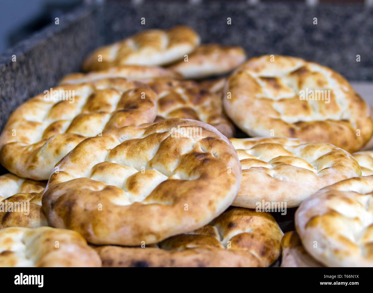Freshly baked bread according to the Uzbek recipe on the bakery table ...