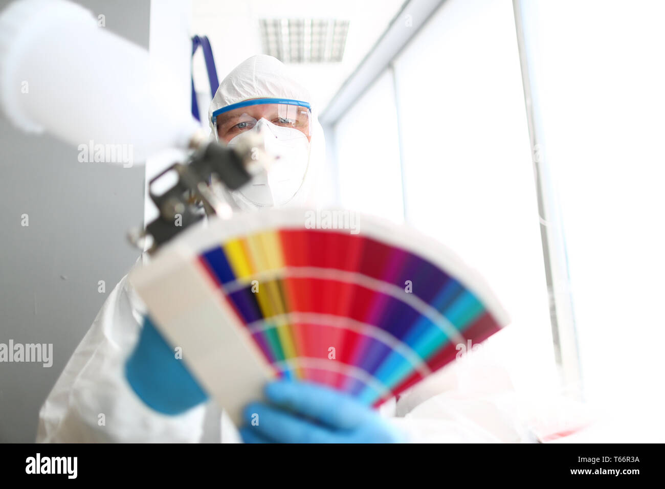 Handyman portrait olding airbrush and colorful fantail Stock Photo - Alamy