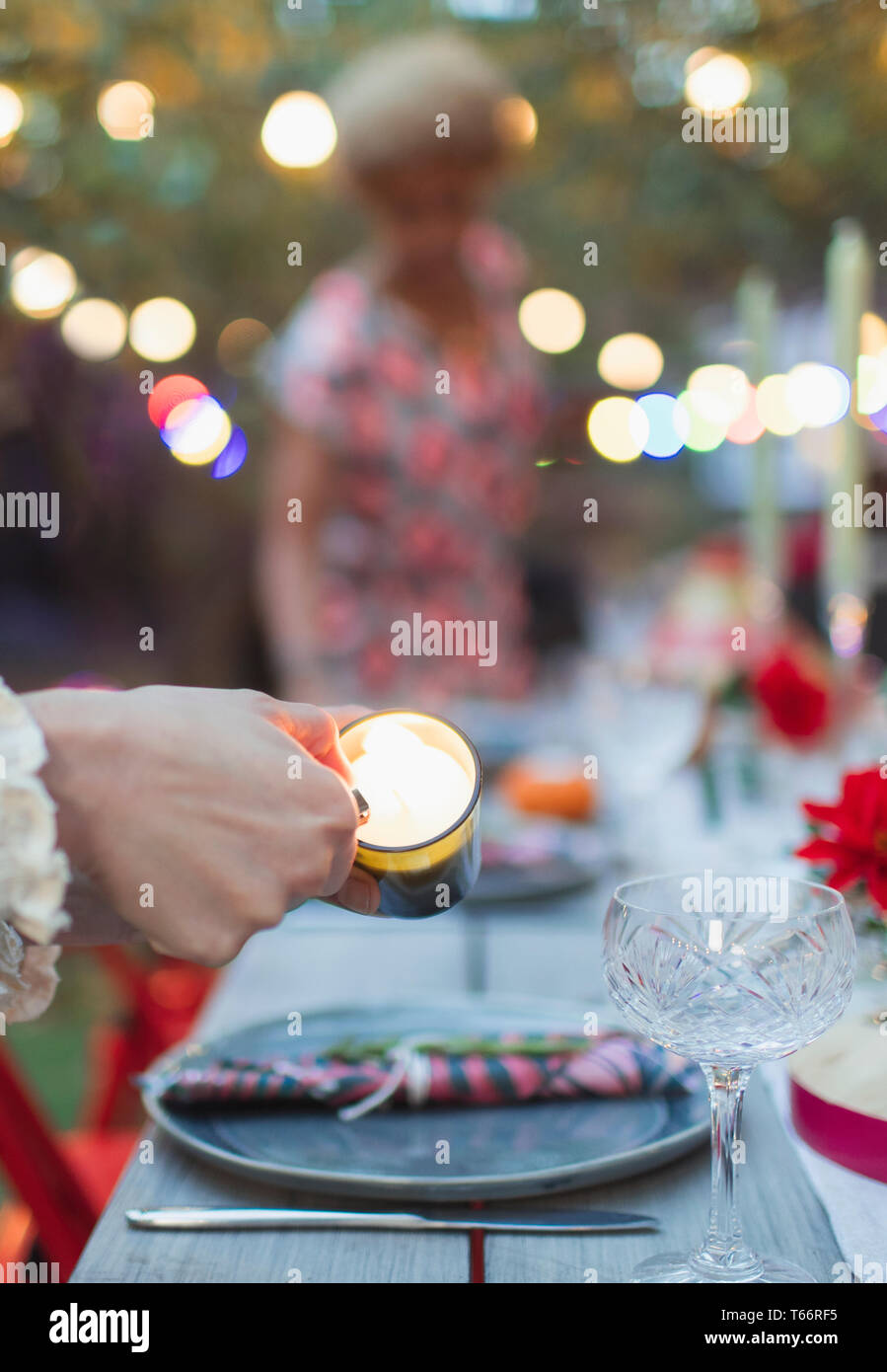 Woman lighting candles for dinner garden party Stock Photo - Alamy