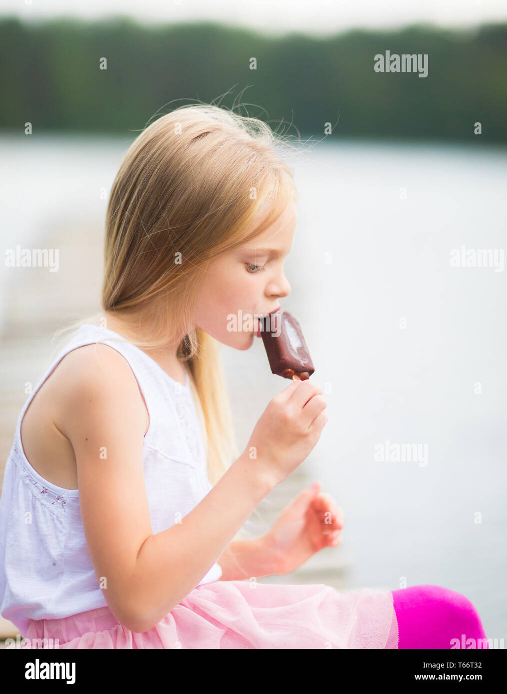 Little girl eats stick ice cream bar eskimo pie Stock Photo - Alamy