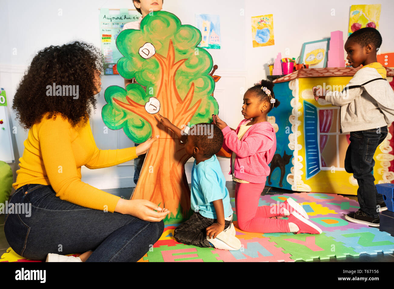 Group of black African descent looking kids learn alphabet by putting ...