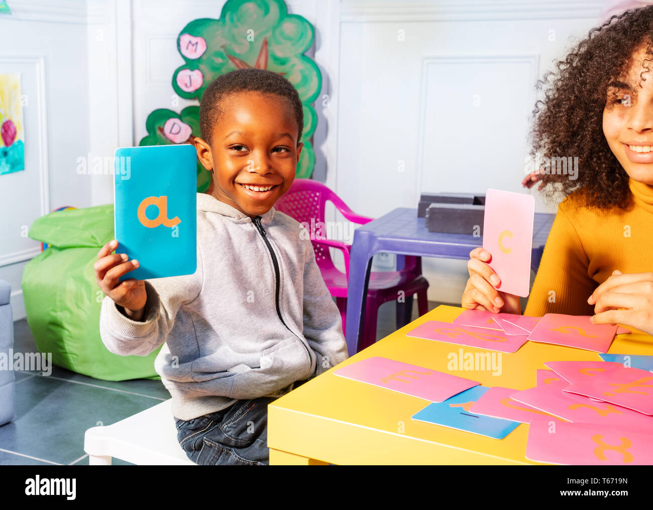 Little black boy showing cursive letter learning with tactile cards ...