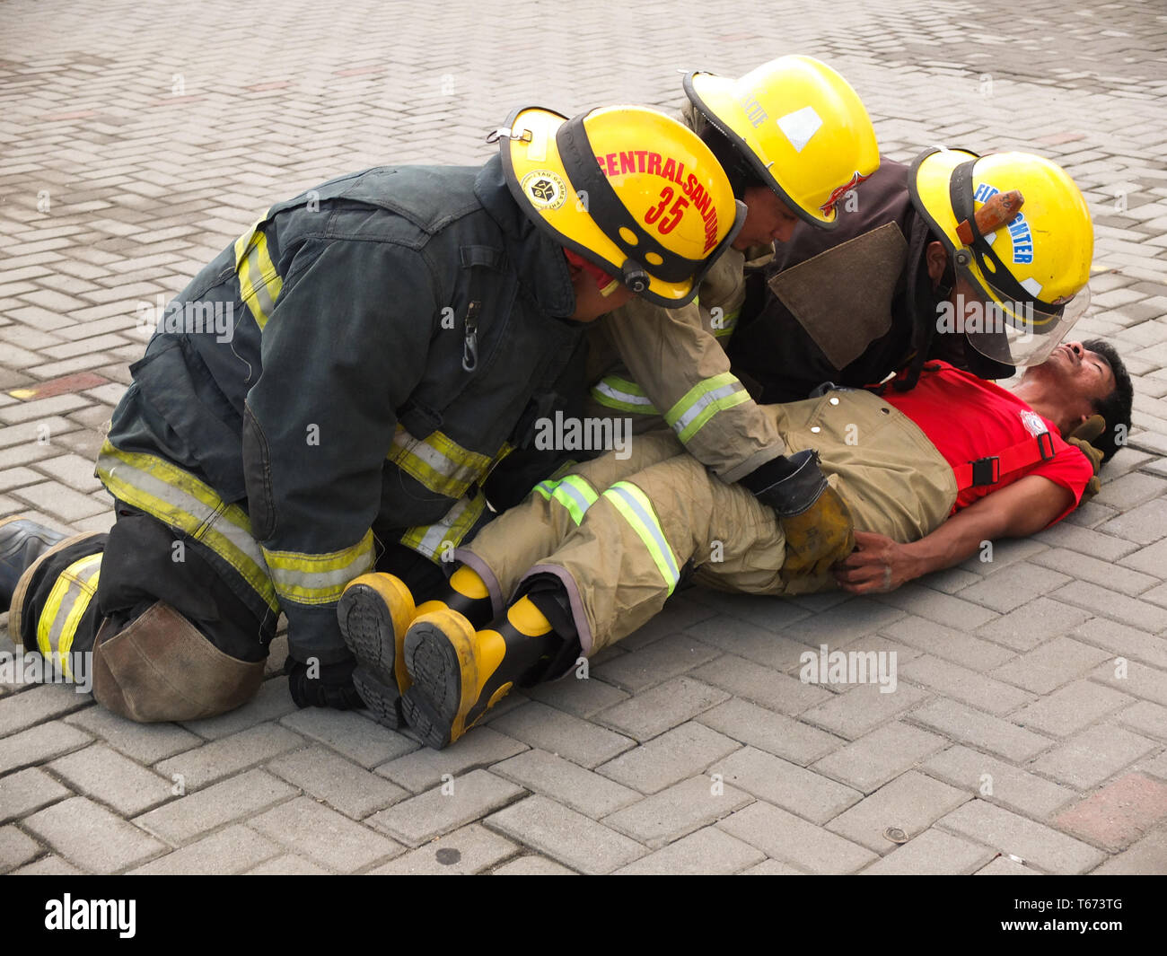 Firemen are seen checking on the vital signs of a wounded victim of ...