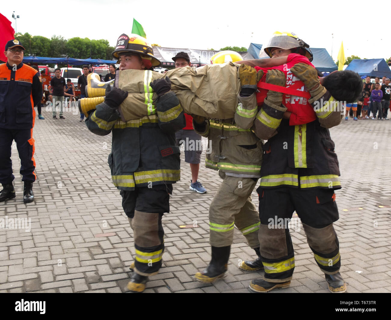 Participating firefighters are seen carrying a wounded patient during a ...