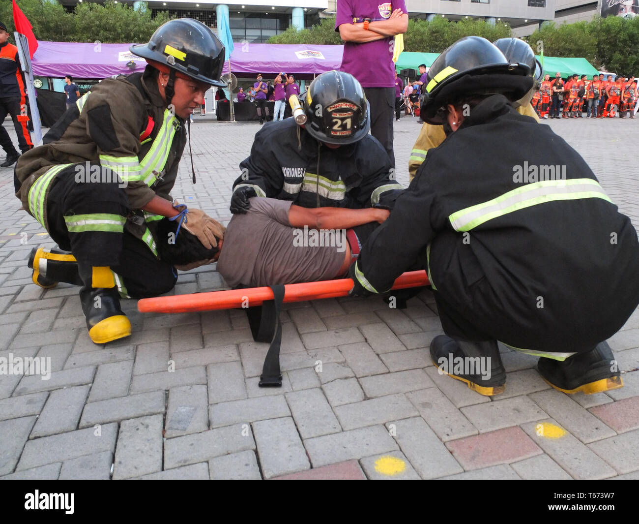 Participating firefighters are seen carrying a wounded patient during a ...