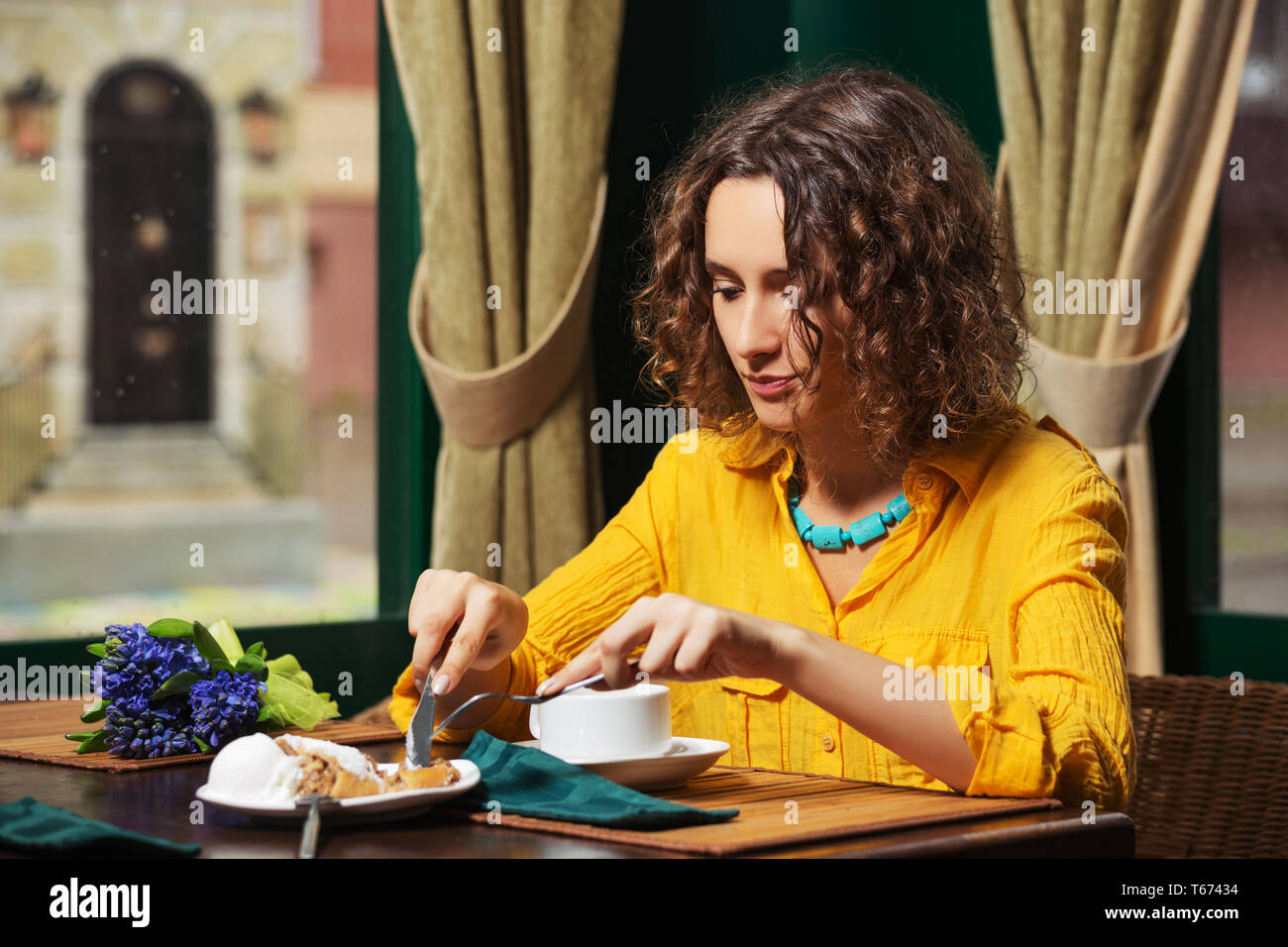 Young fashion woman eating cake at restaurant Stylish female model with ...