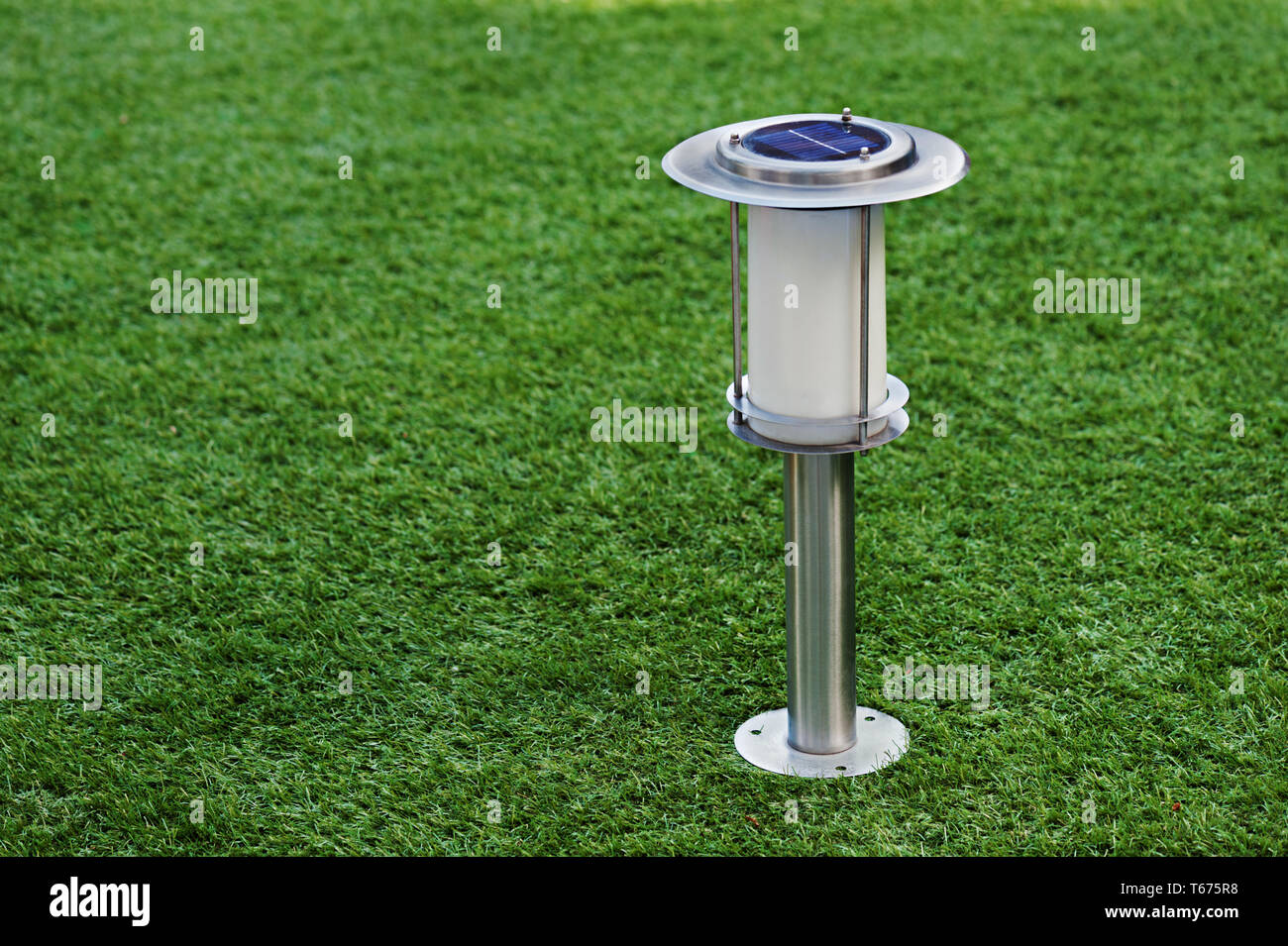Solar-powered lamp on green grass background. Sele Stock Photo - Alamy