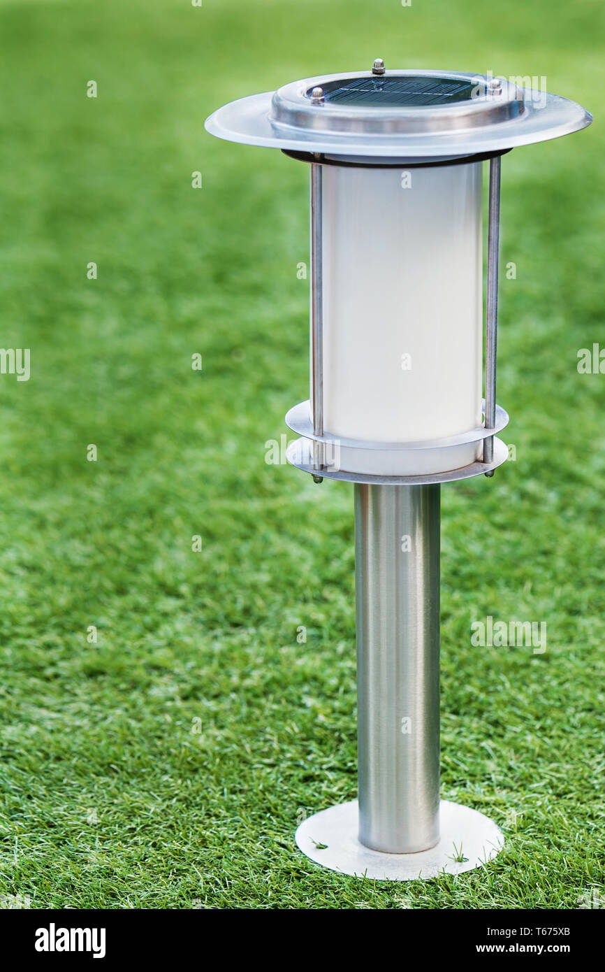 Solar-powered lamp on green grass background. Sele Stock Photo - Alamy