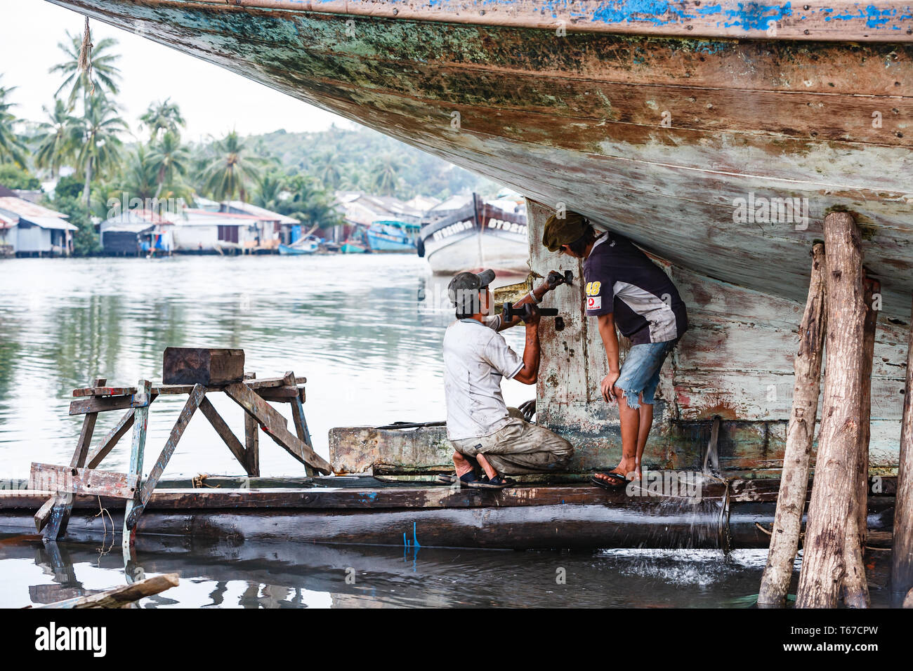 Closeup of men working on the hull of ship in dockyard in Vietnam Stock ...
