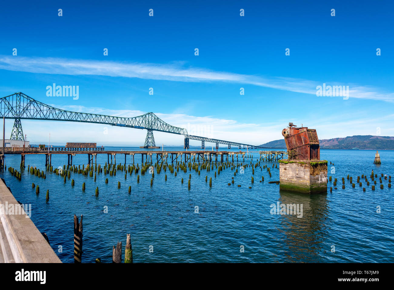 Ruins of an old historic pier with the Astoria Megler Bridge in the ...