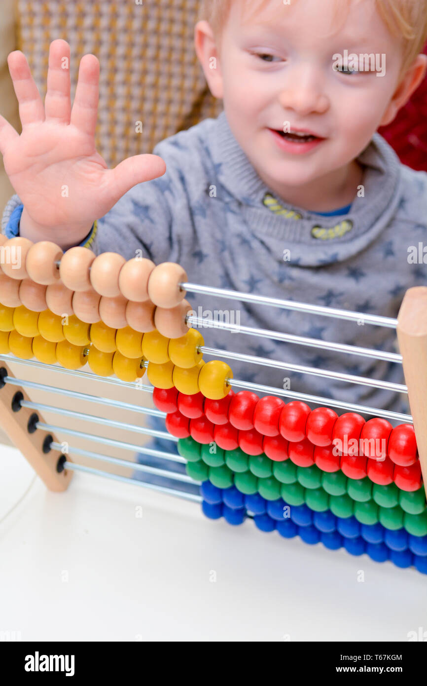 Child learning to count. Young boy using an abacus to learn maths Stock ...