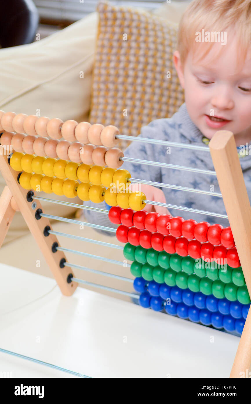 Child learning to count. Young boy using an abacus to learn maths Stock ...