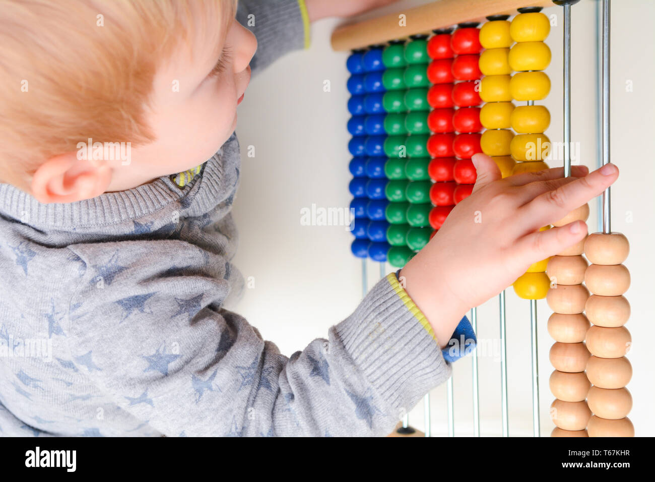 Child learning to count. Young boy using an abacus to learn maths Stock ...
