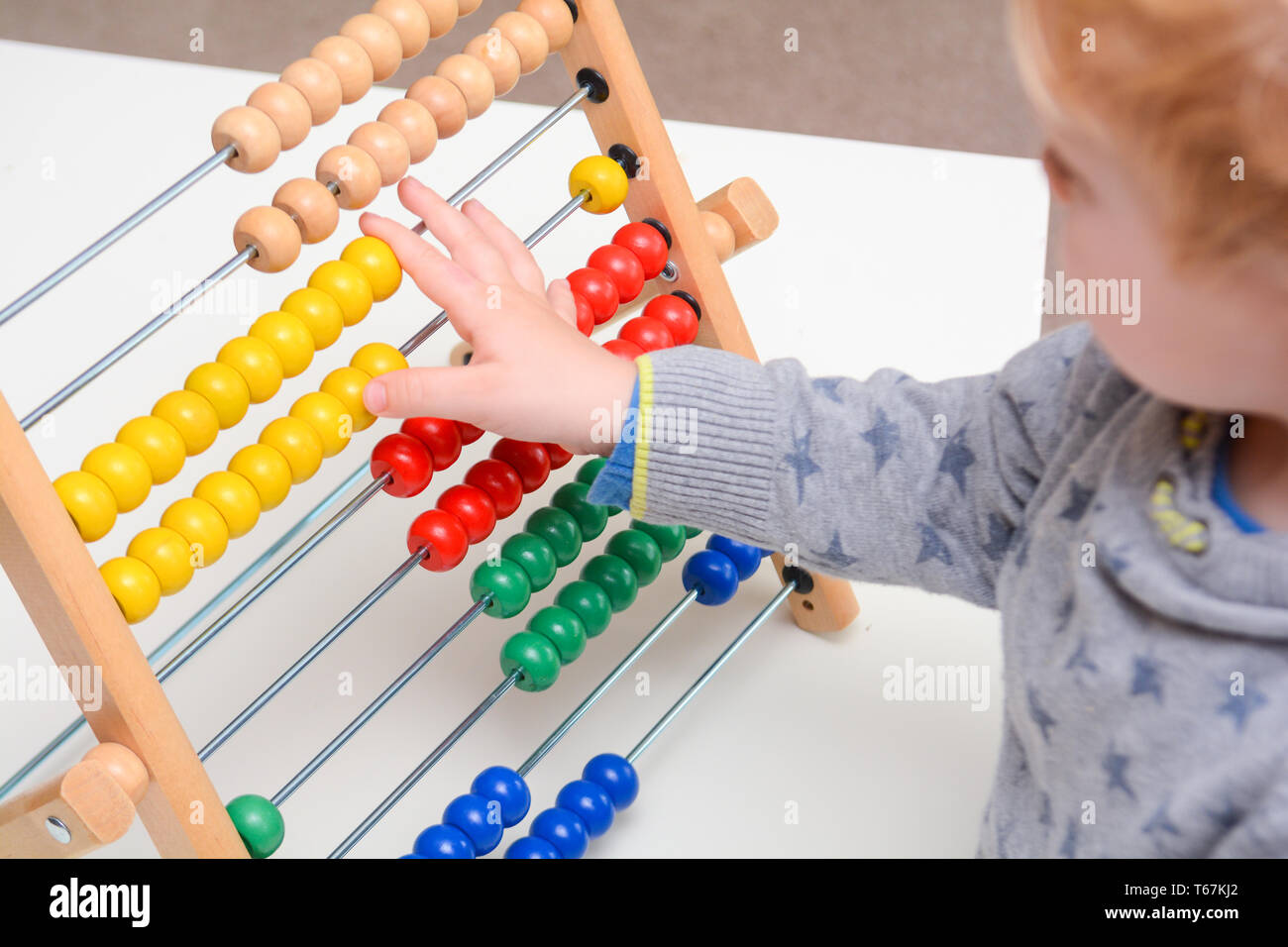 Child learning to count. Young boy using an abacus to learn maths Stock ...