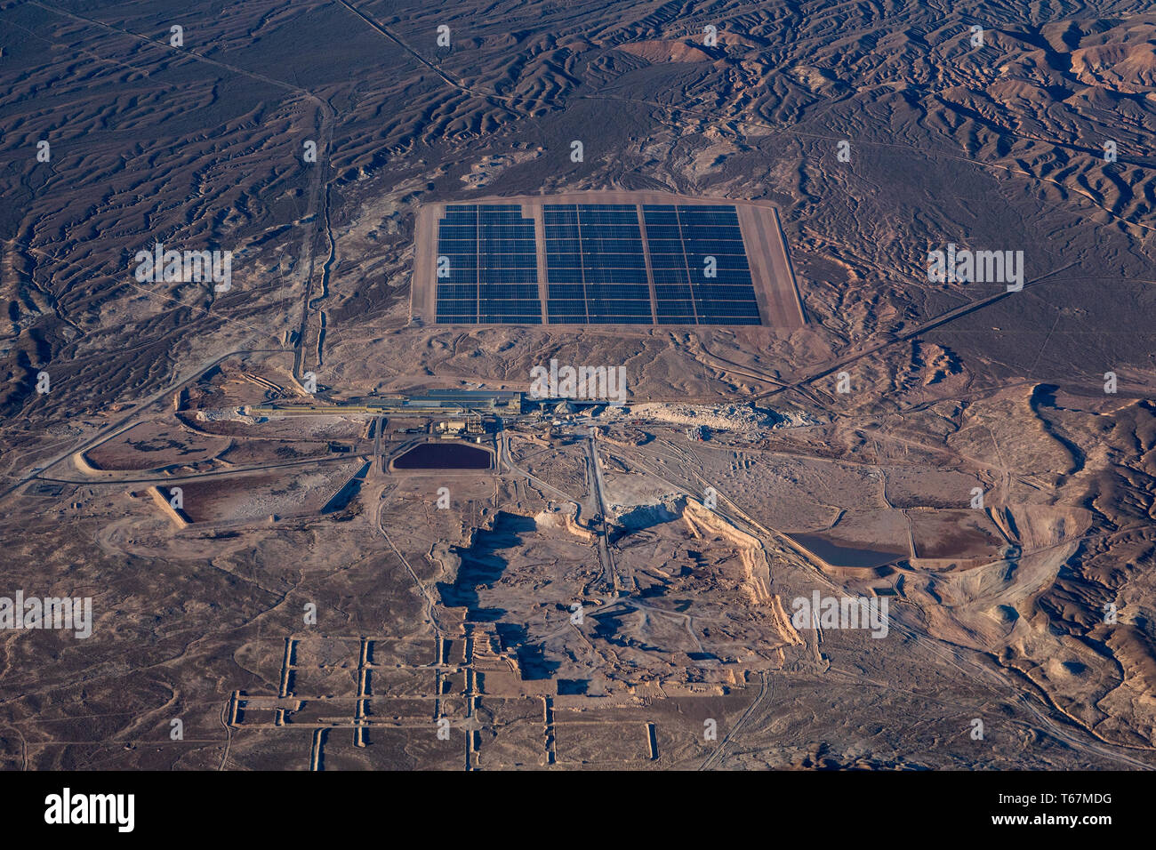 A huge photo-voltaic solar power plant in the desert landscape outside ...