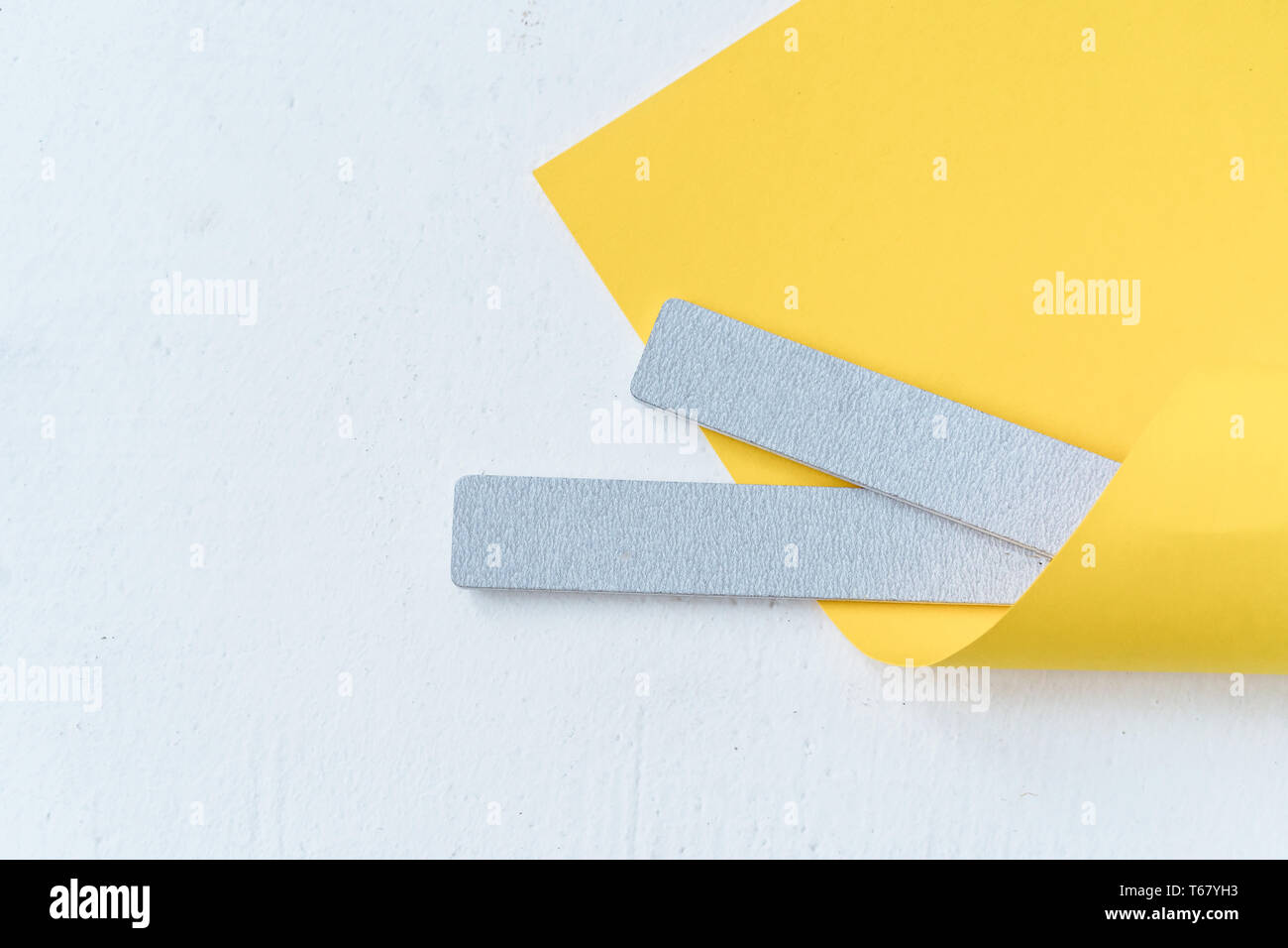 gray nail file wrapped in yellow paper Stock Photo - Alamy