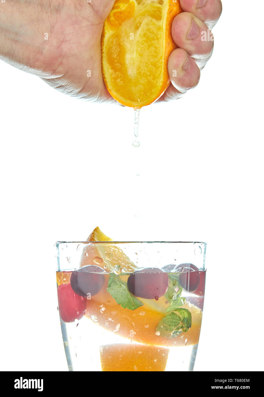 squeezing orange juice pouring into a glass isolated on white. water ...