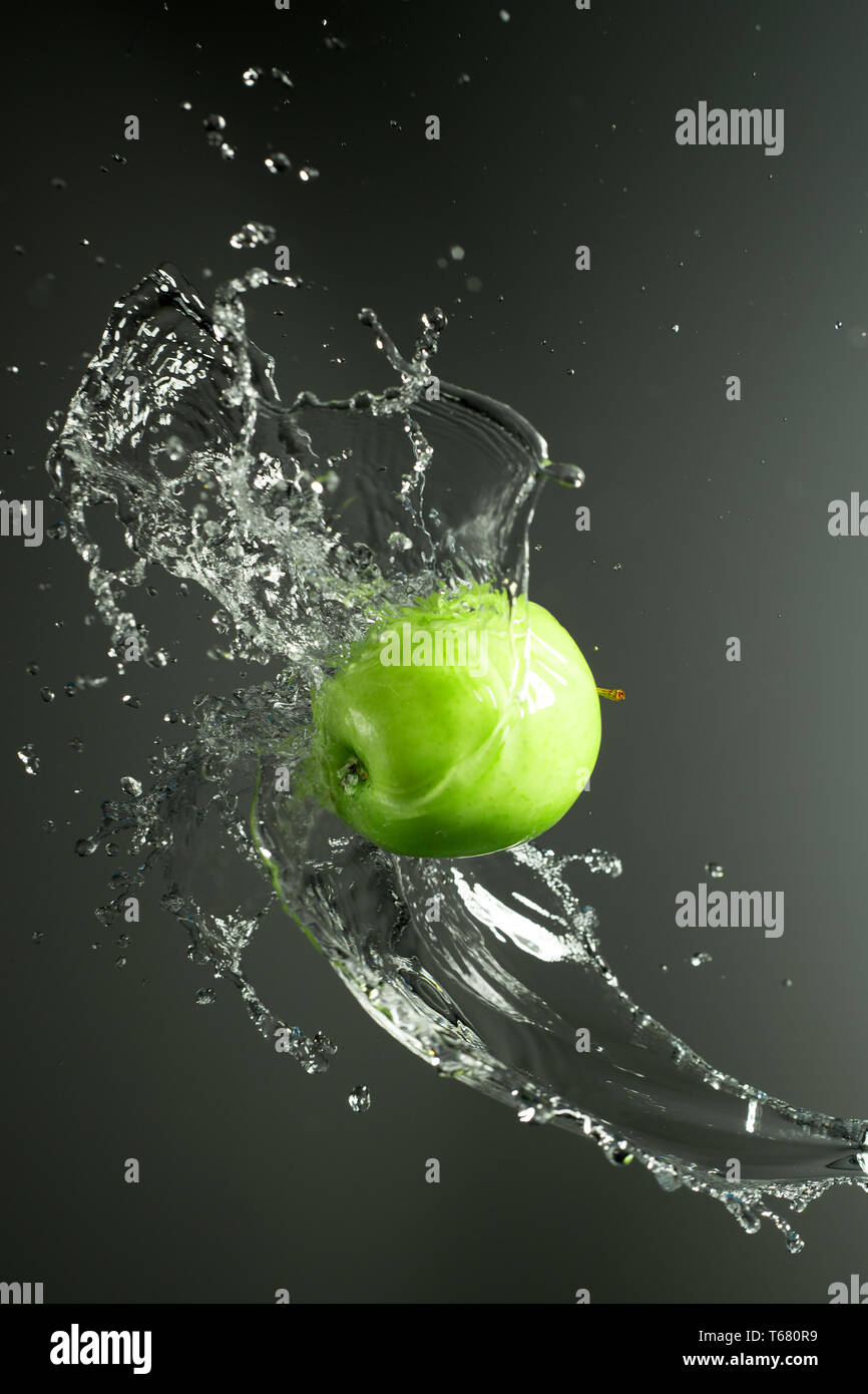 Green apple with water splash, on black Stock Photo - Alamy