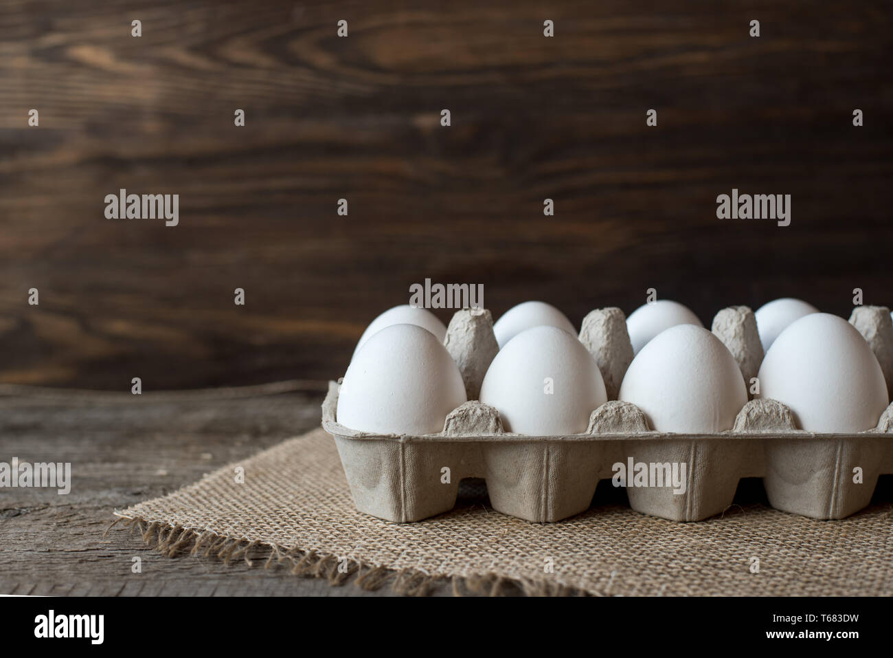 Raw white eggs in egg box on wooden background Stock Photo - Alamy