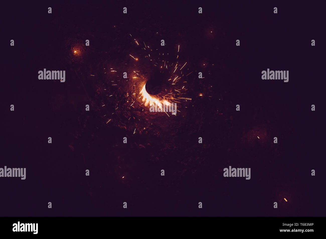 Firecrackers spinning over themselves at night, throwing sparks of fire ...