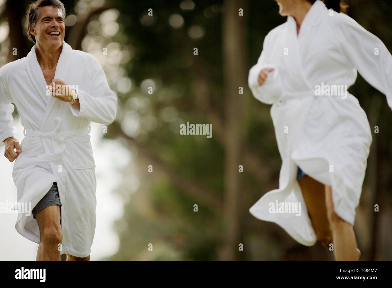 Mid-adult man chasing after his wife Stock Photo - Alamy