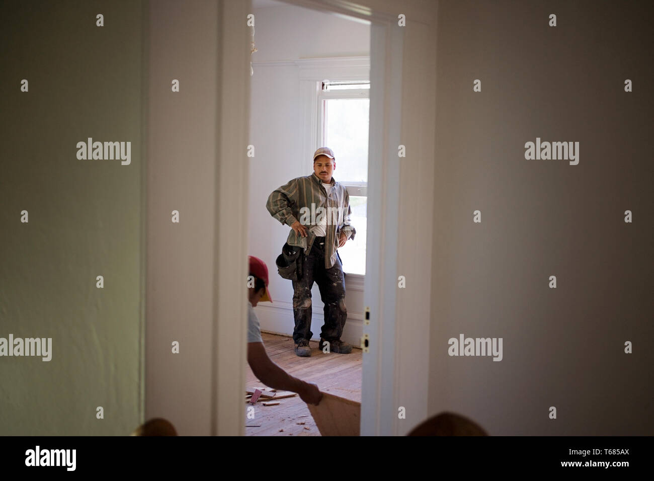 Two builders working inside a room in a house Stock Photo - Alamy