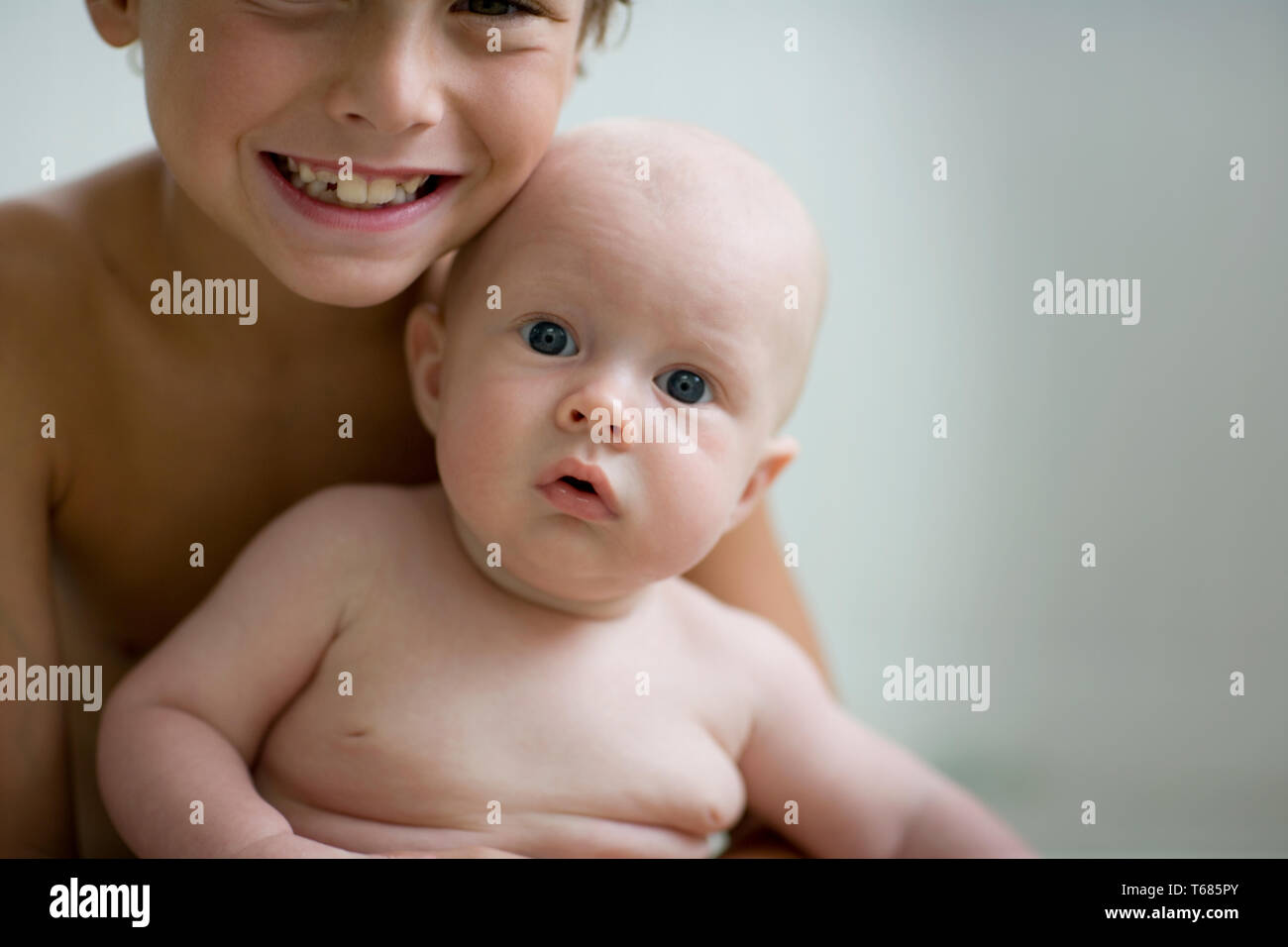 Portrait of a young boy holding his baby brother Stock Photo - Alamy