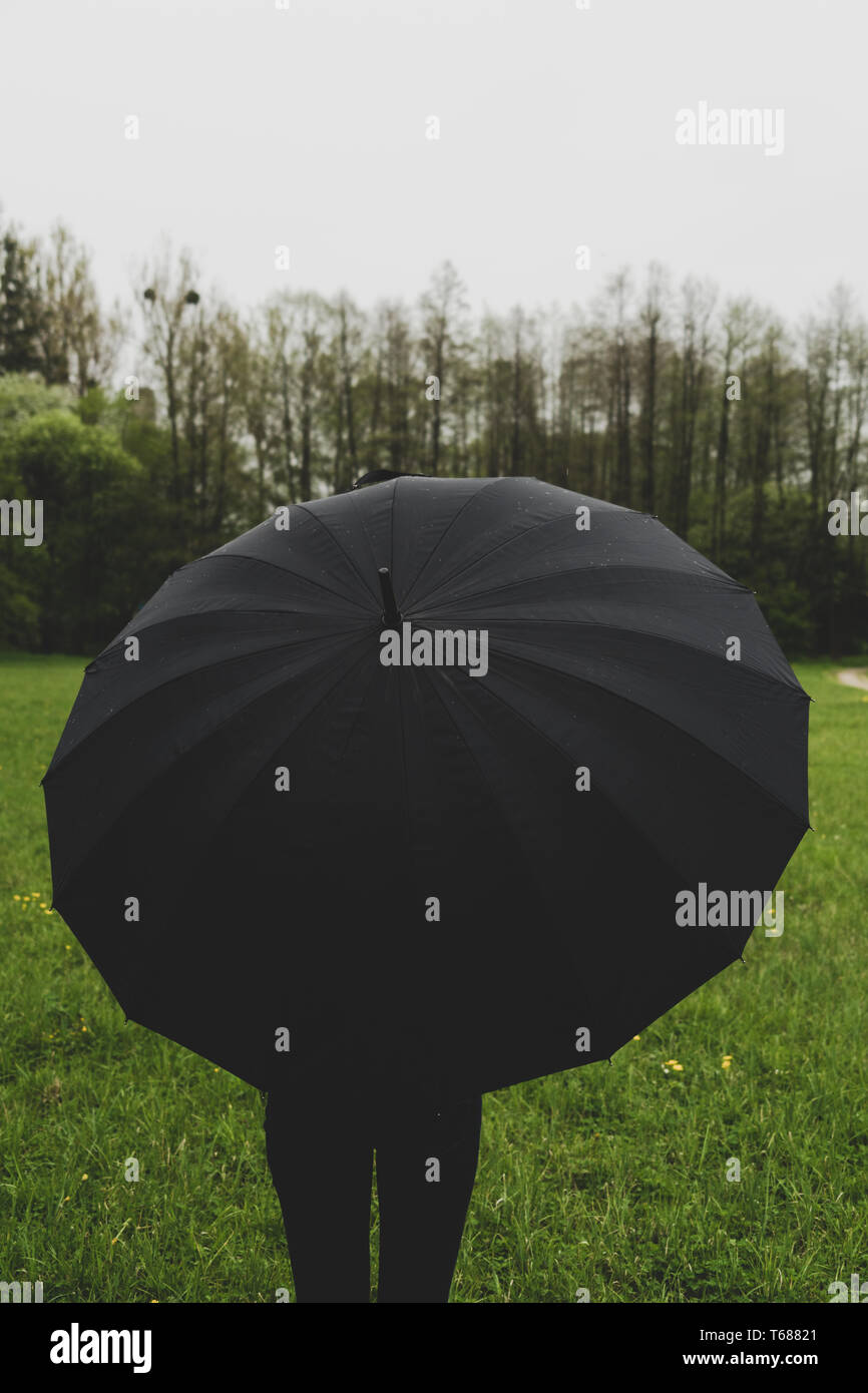 Back Umbrella in the rain. Park visible in background Stock Photo - Alamy