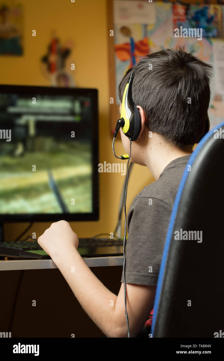 Boy using computer at home, playing game Stock Photo - Alamy