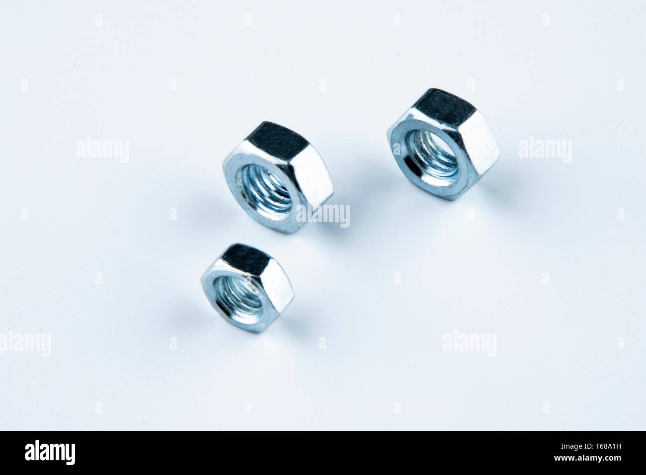 Three metal nuts on a white background Stock Photo - Alamy