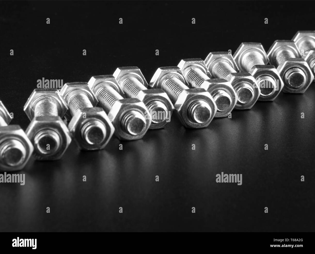 Nuts and bolts closeup on black background Stock Photo - Alamy