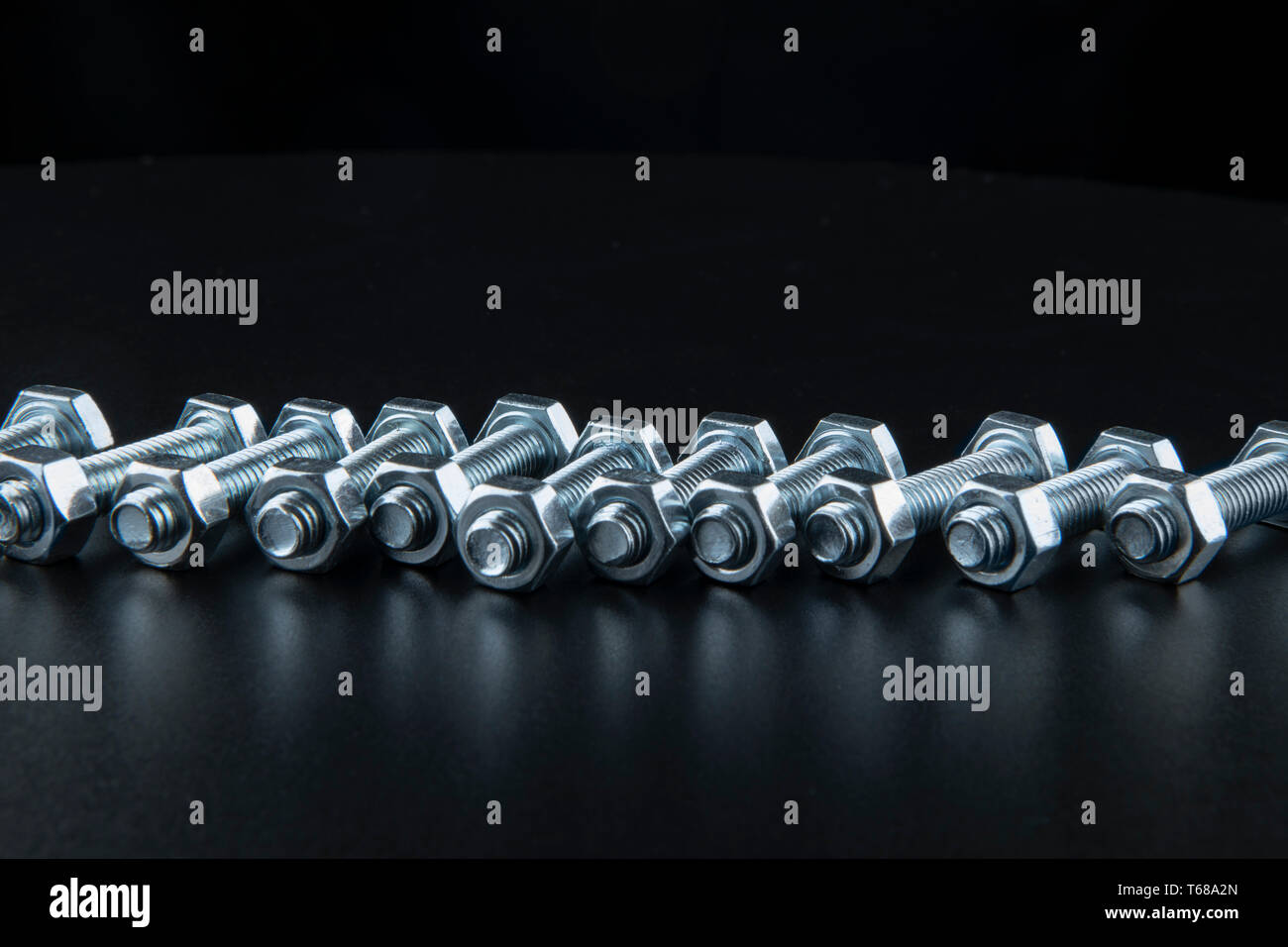 Nuts and bolts closeup on black background Stock Photo - Alamy