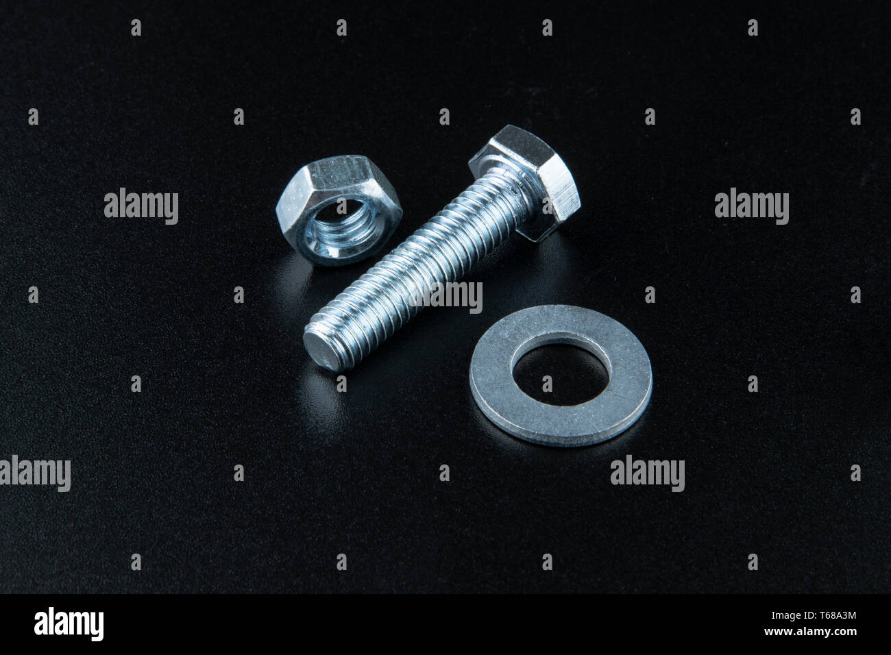 Nut and bolt close up on black background Stock Photo - Alamy
